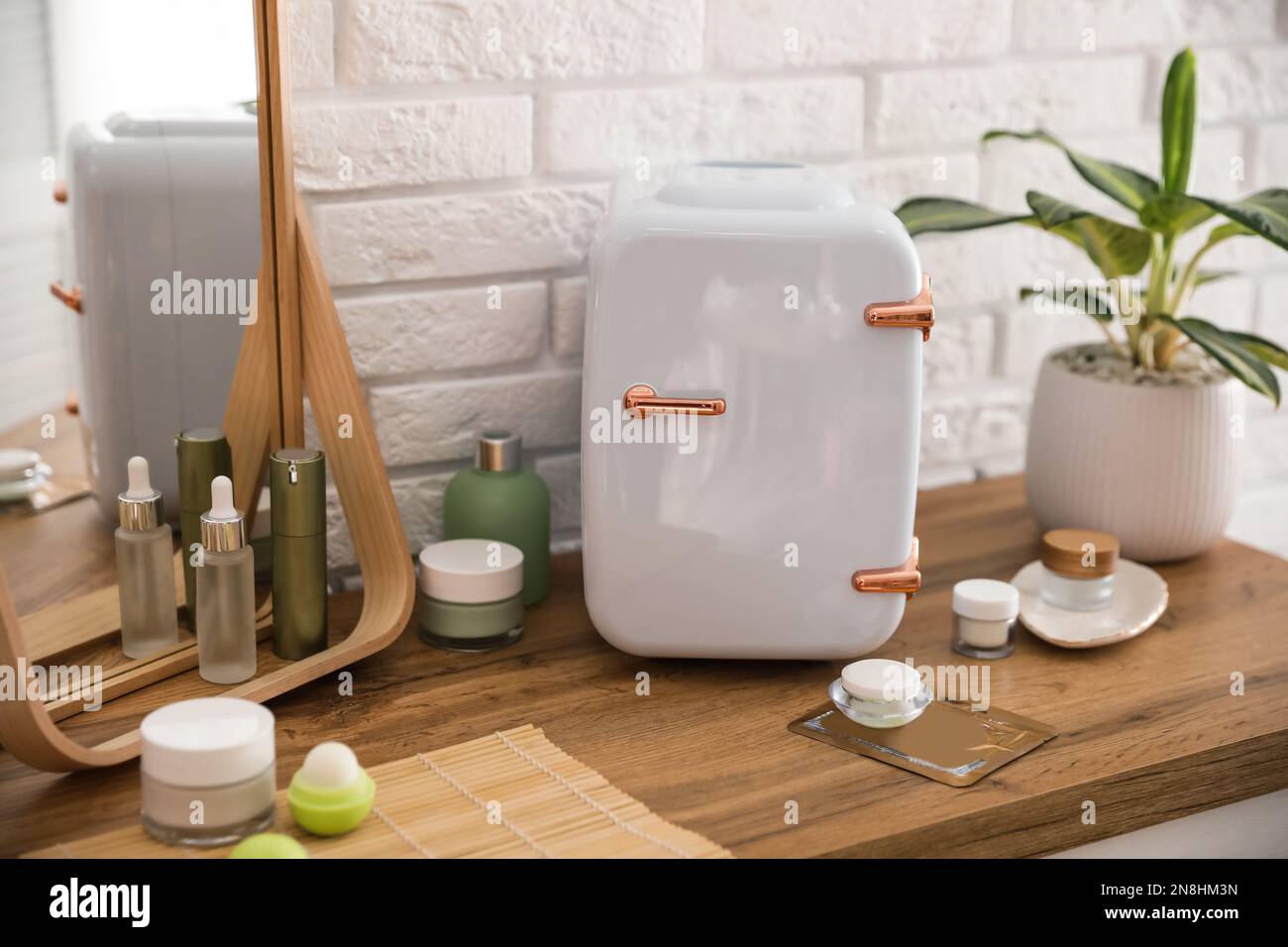 Mini fridge for cosmetic products on wooden vanity table Stock Photo ...