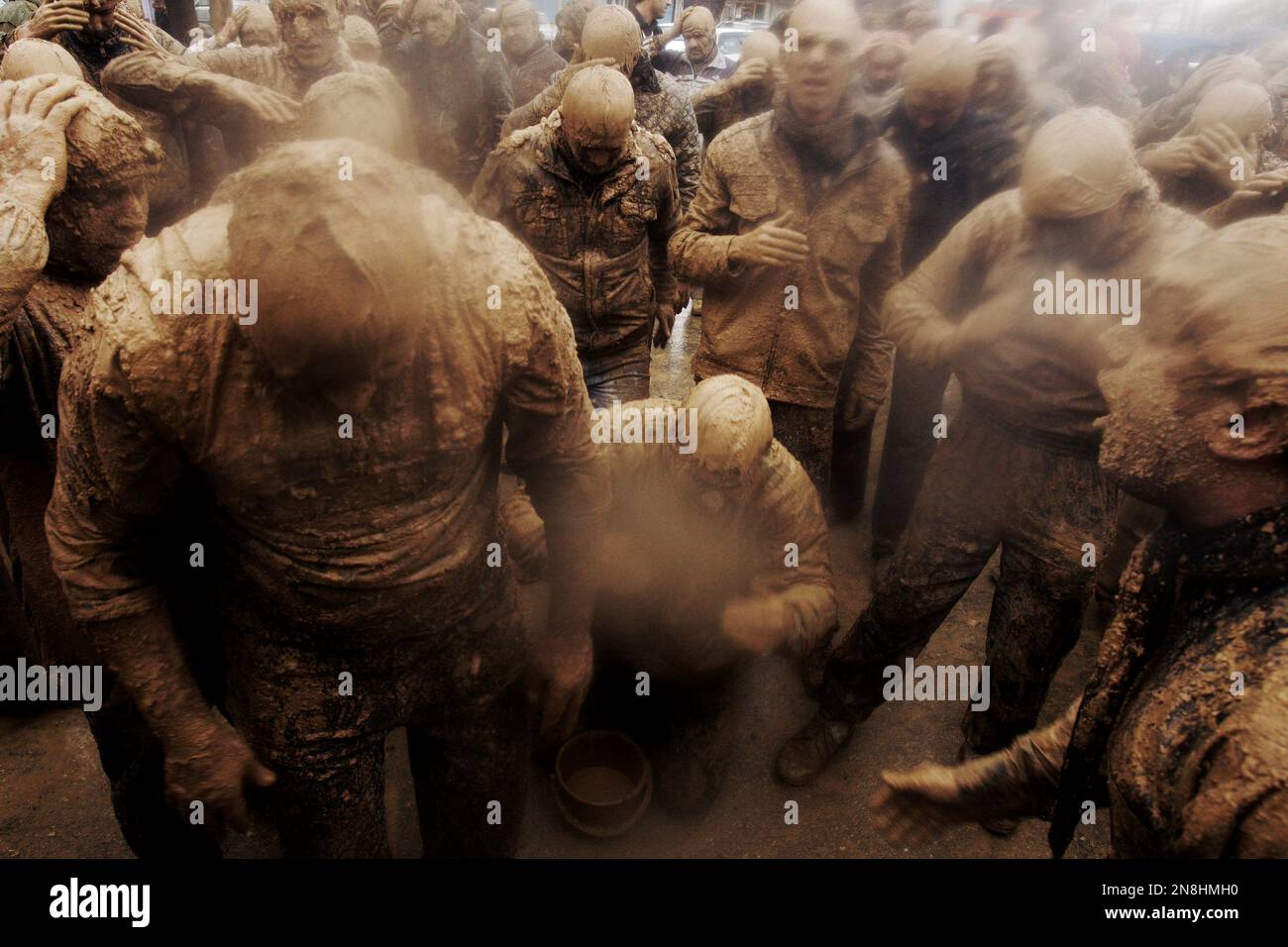 Iranian mourners cover themselves with mud, during Ashoura rituals ...