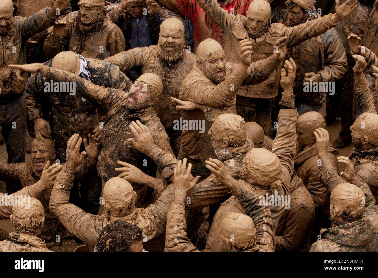 Iranian mourners beat their heads, as they cover themselves with mud ...