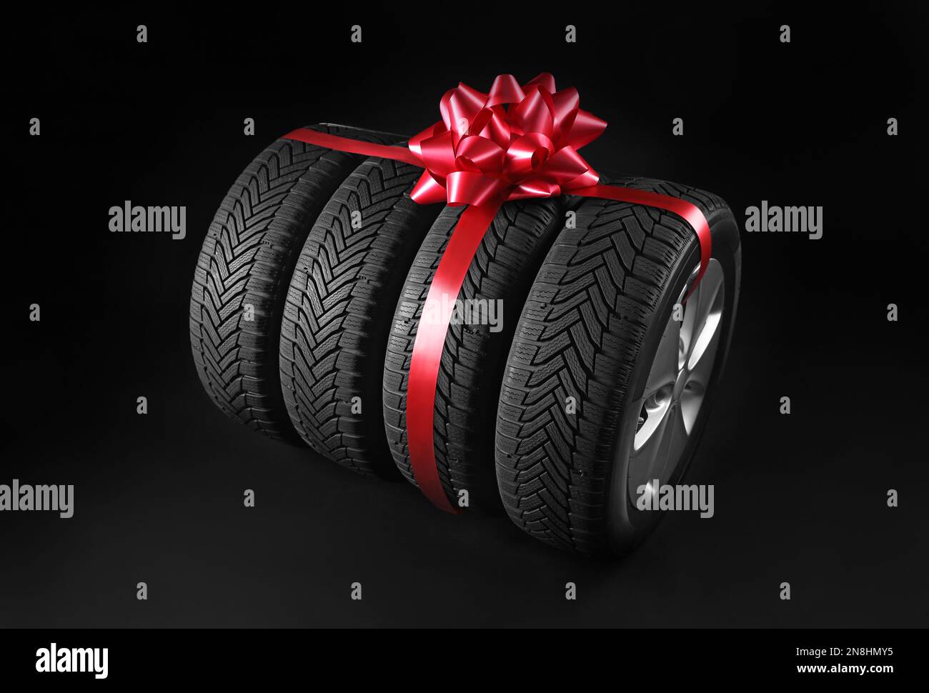 Gift set of wheels with winter tires on black background Stock Photo ...