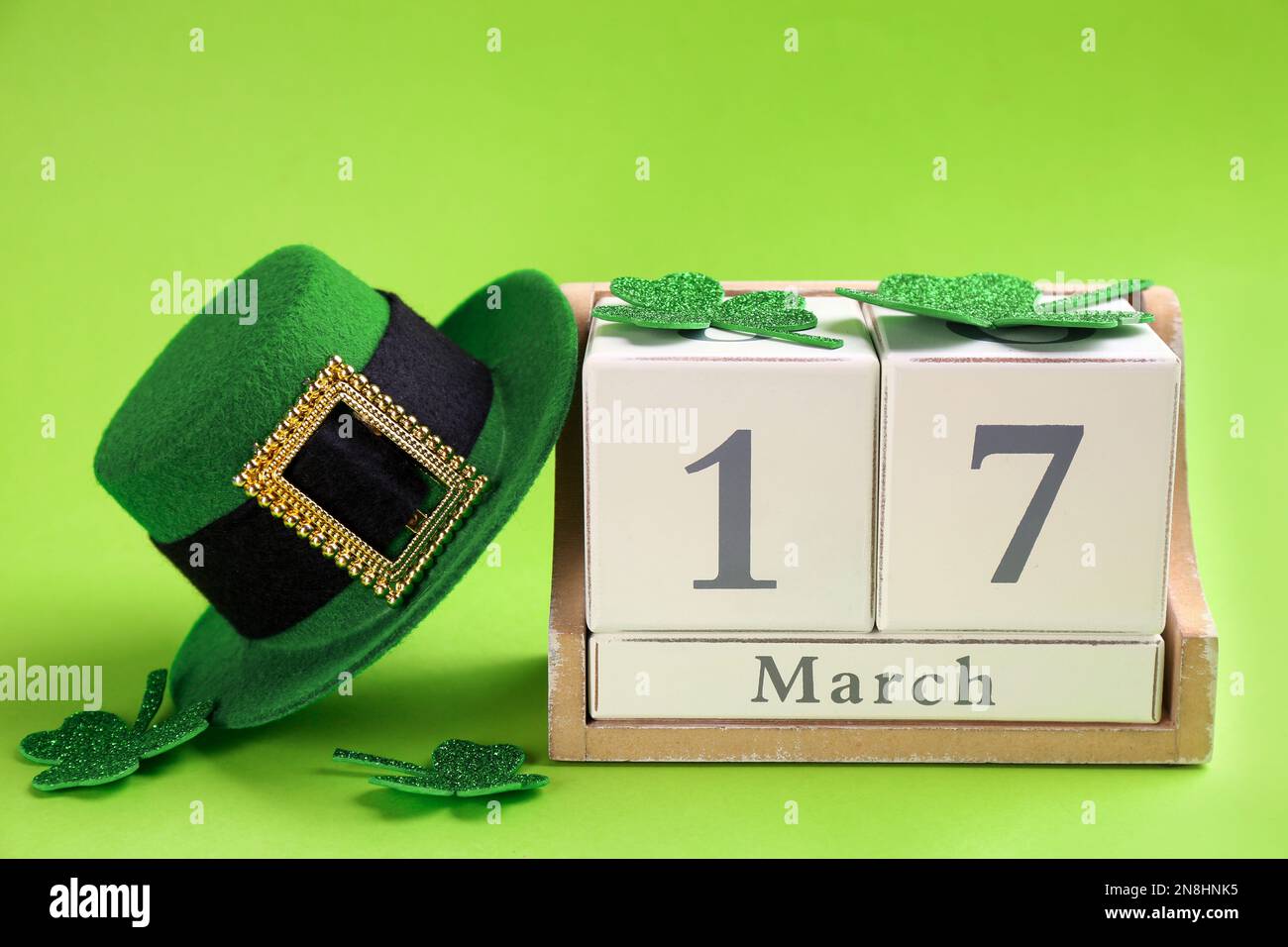 Leprechaun's hat, block calendar and St. Patrick's day decor on green ...