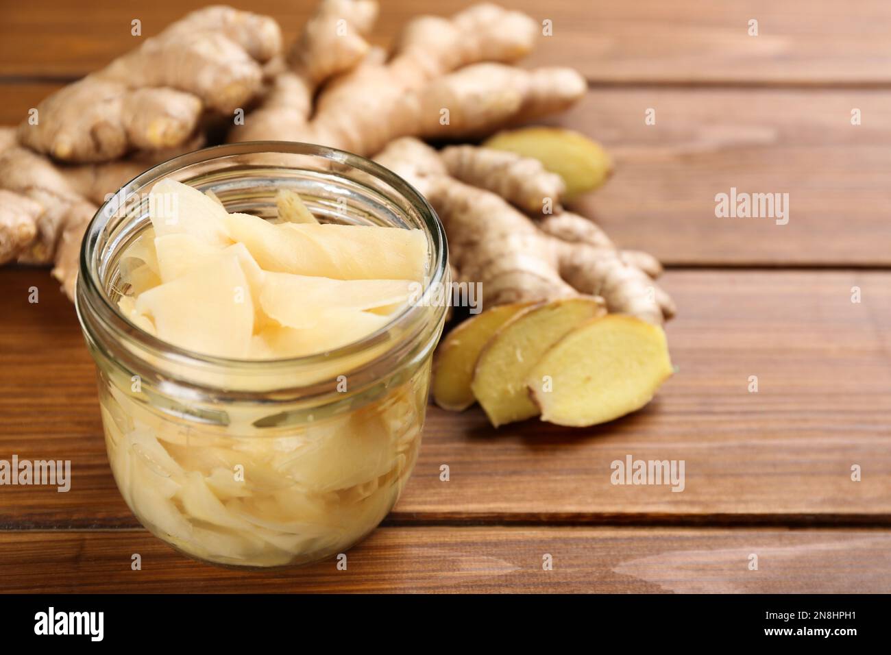 Spicy pickled ginger and root on wooden table, space for text Stock Photo - Alamy