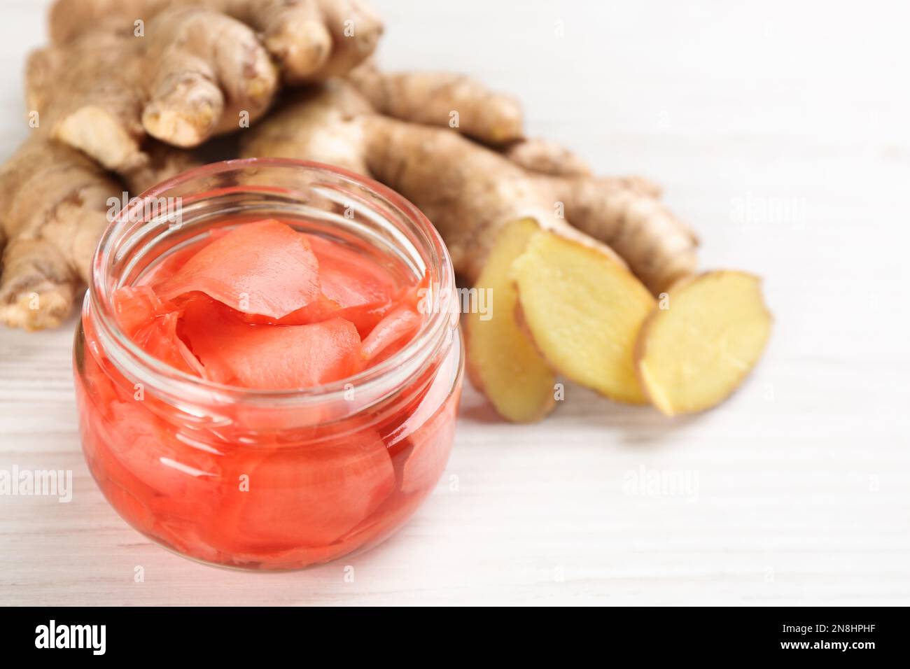 Spicy pickled ginger and root on white wooden table, space for text Stock Photo - Alamy