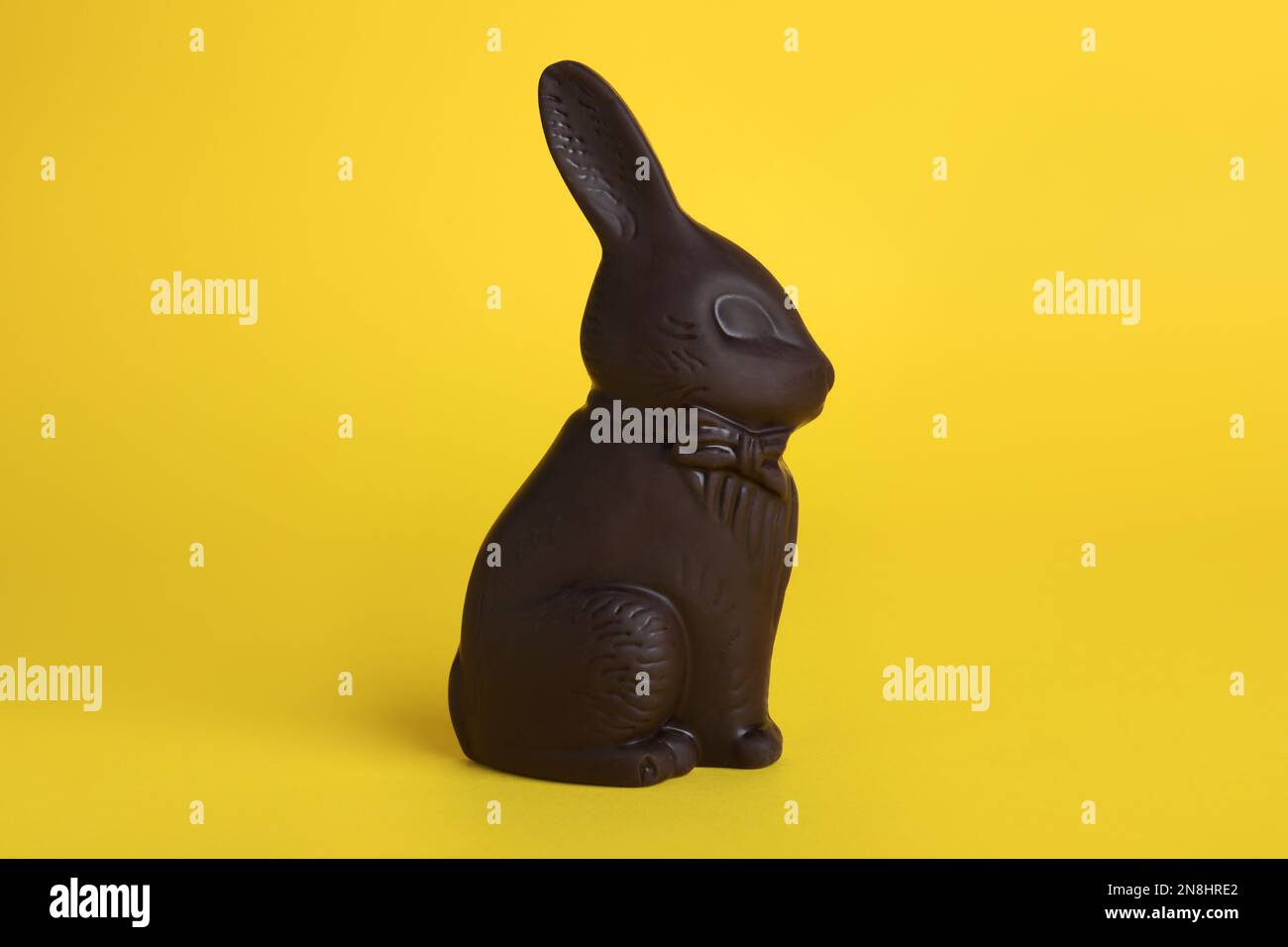 Dark chocolate bunny on yellow background. Easter celebration Stock ...