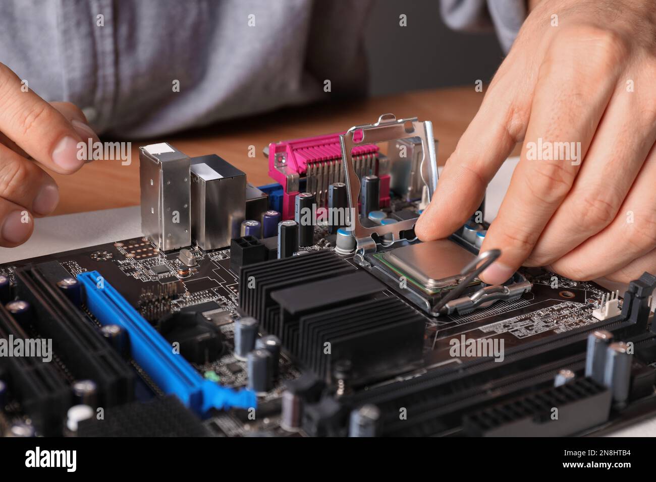 Technician repairing computer motherboard at table, closeup. Electronic device Stock Photo - Alamy
