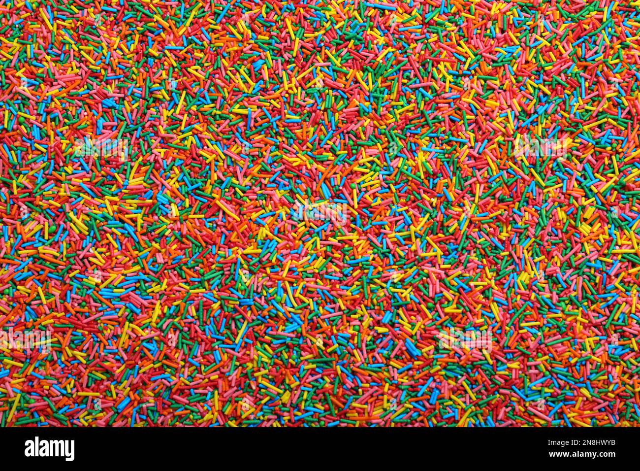 Bright colorful sprinkles as background, top view. Confectionery decor ...