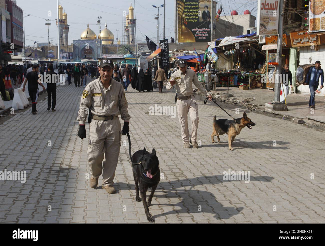 Two Iraqi policemen check the area around Imam Moussa al-Kadhim shrine ...