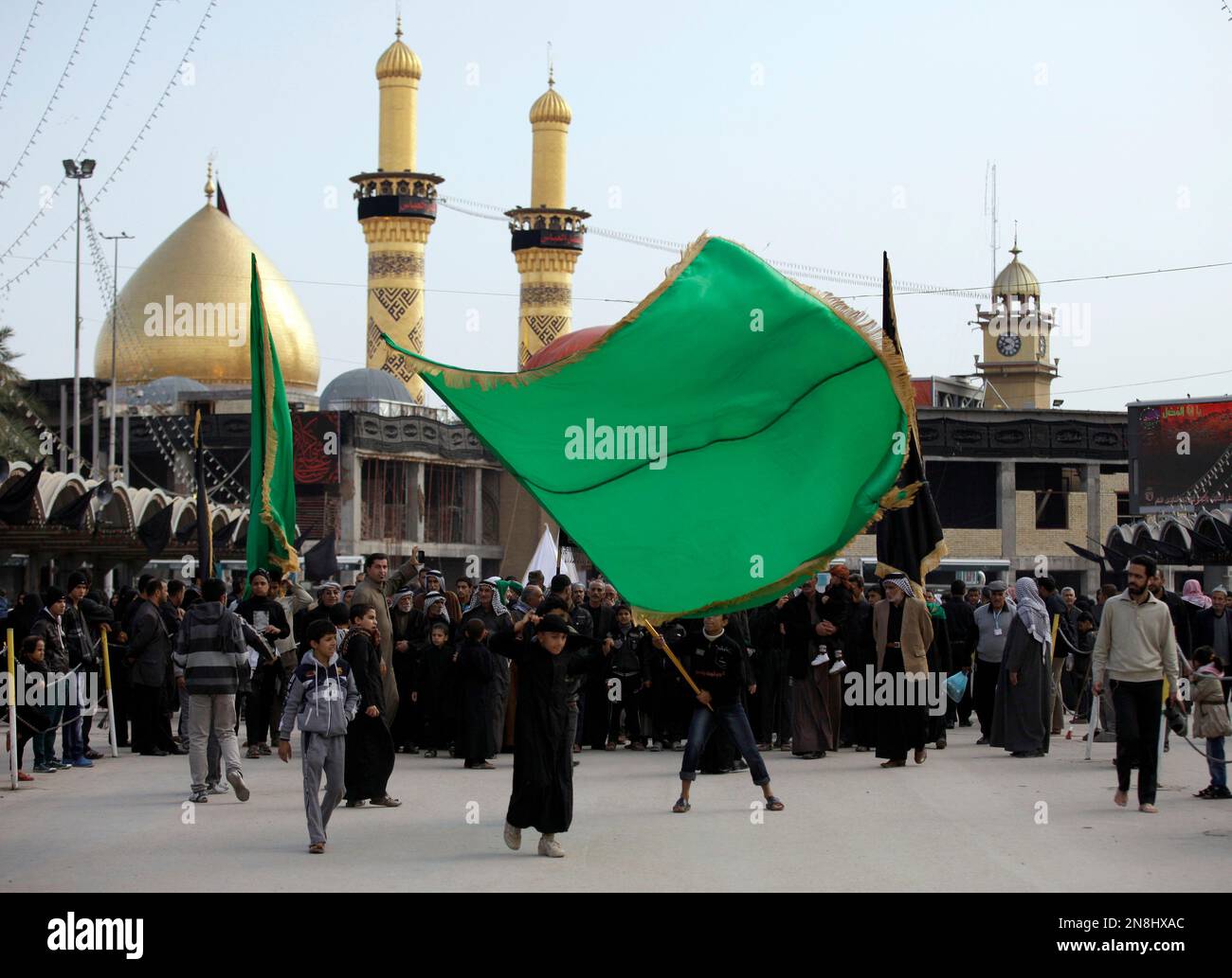 A Shiite Muslim worshipper waves a green flag, the traditional color of ...