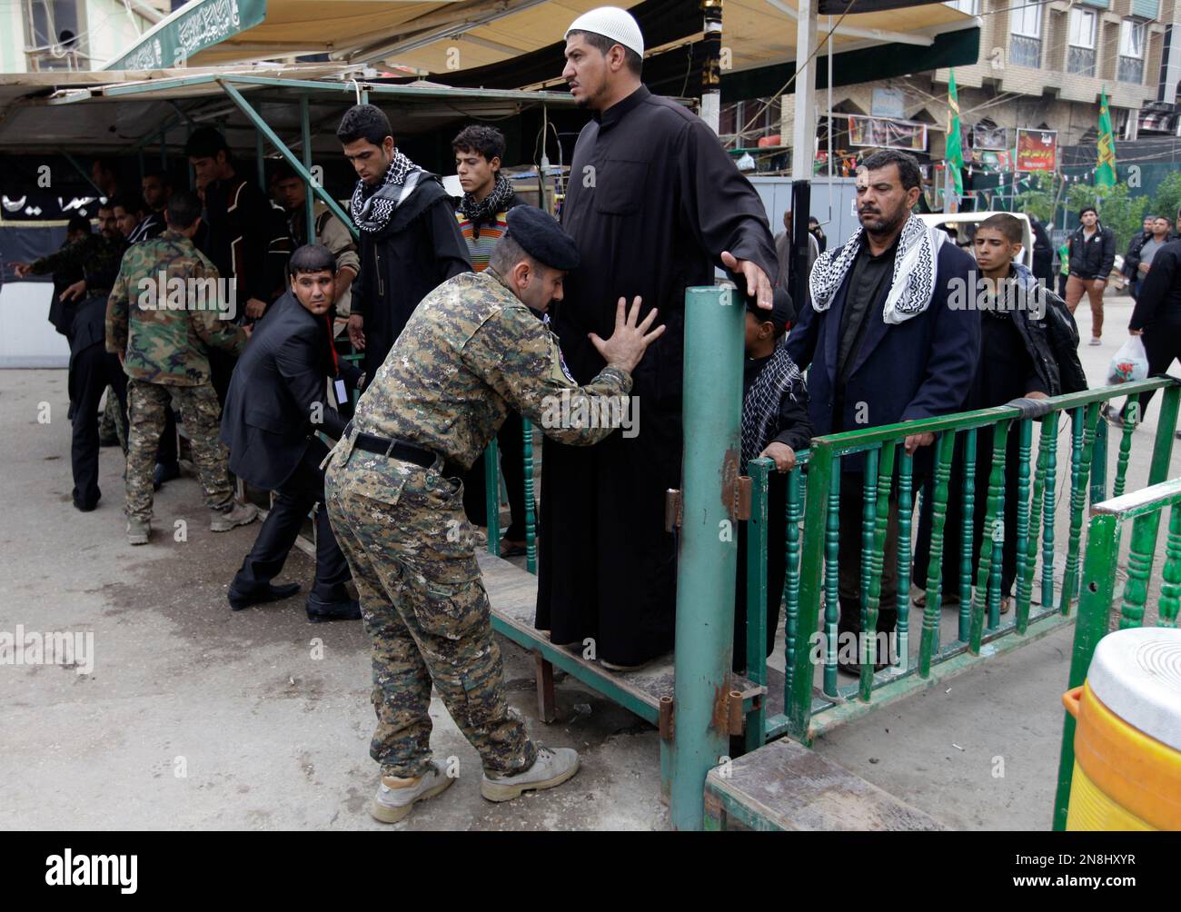 Iraqi soldiers search Shiite Muslim worshippers who arrived to attend ...