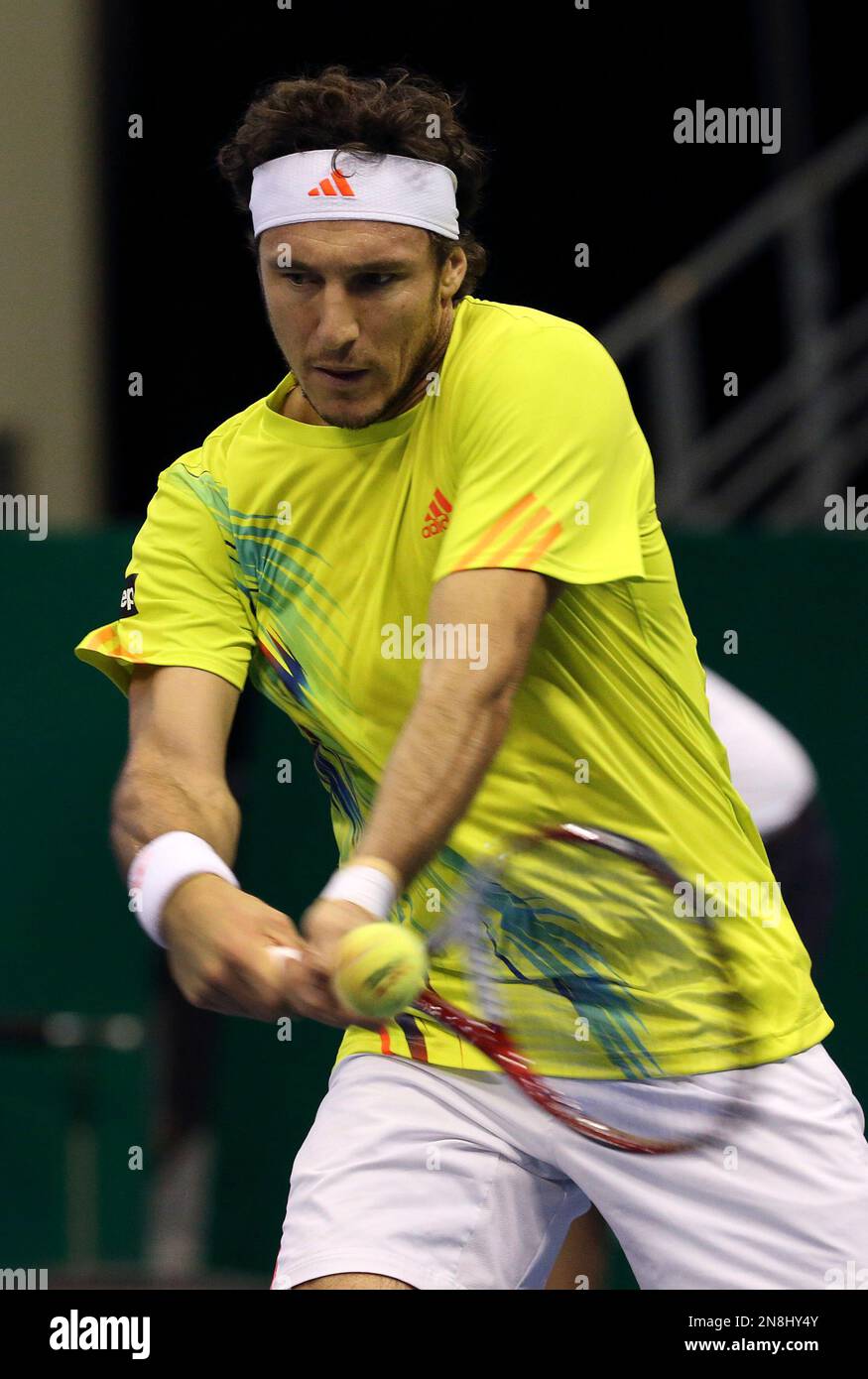 Juan Monaco of Argentina returns a shot to Kei Nishikori of Japan ...