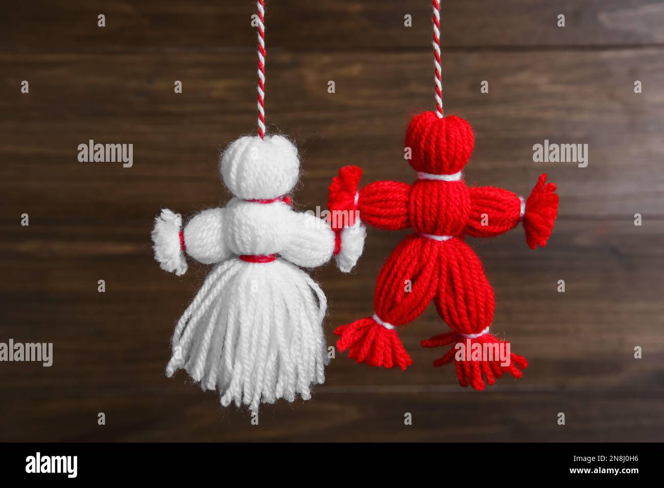 Traditional martisor shaped as man and woman on wooden background ...
