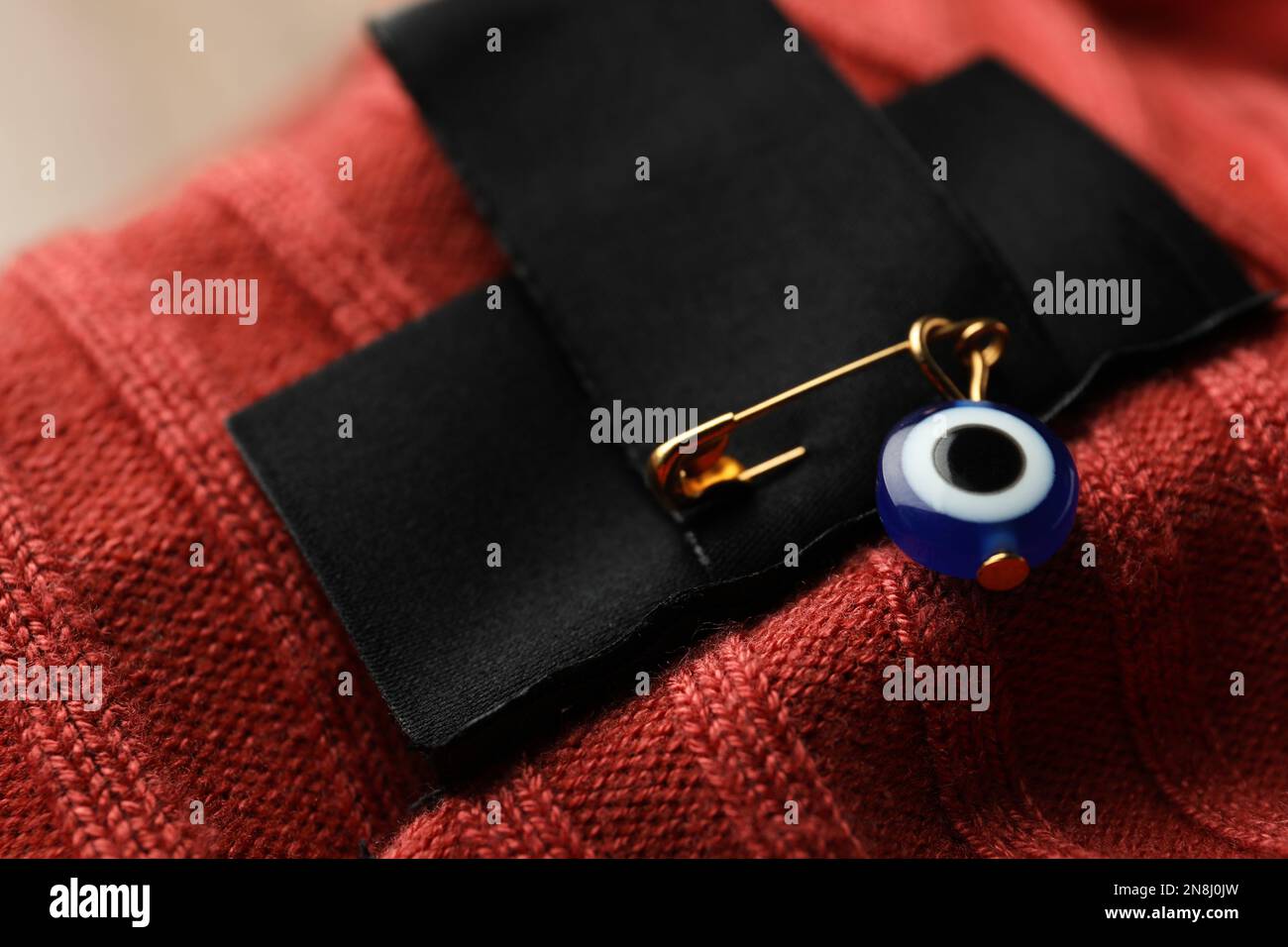 Evil eye safety pin on clothing, closeup Stock Photo - Alamy