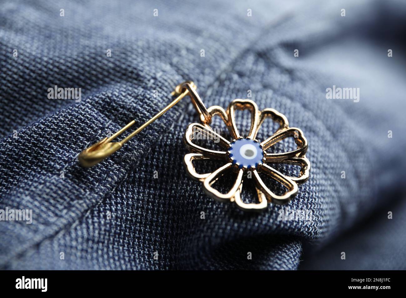 Evil eye safety pin on clothing, closeup Stock Photo - Alamy
