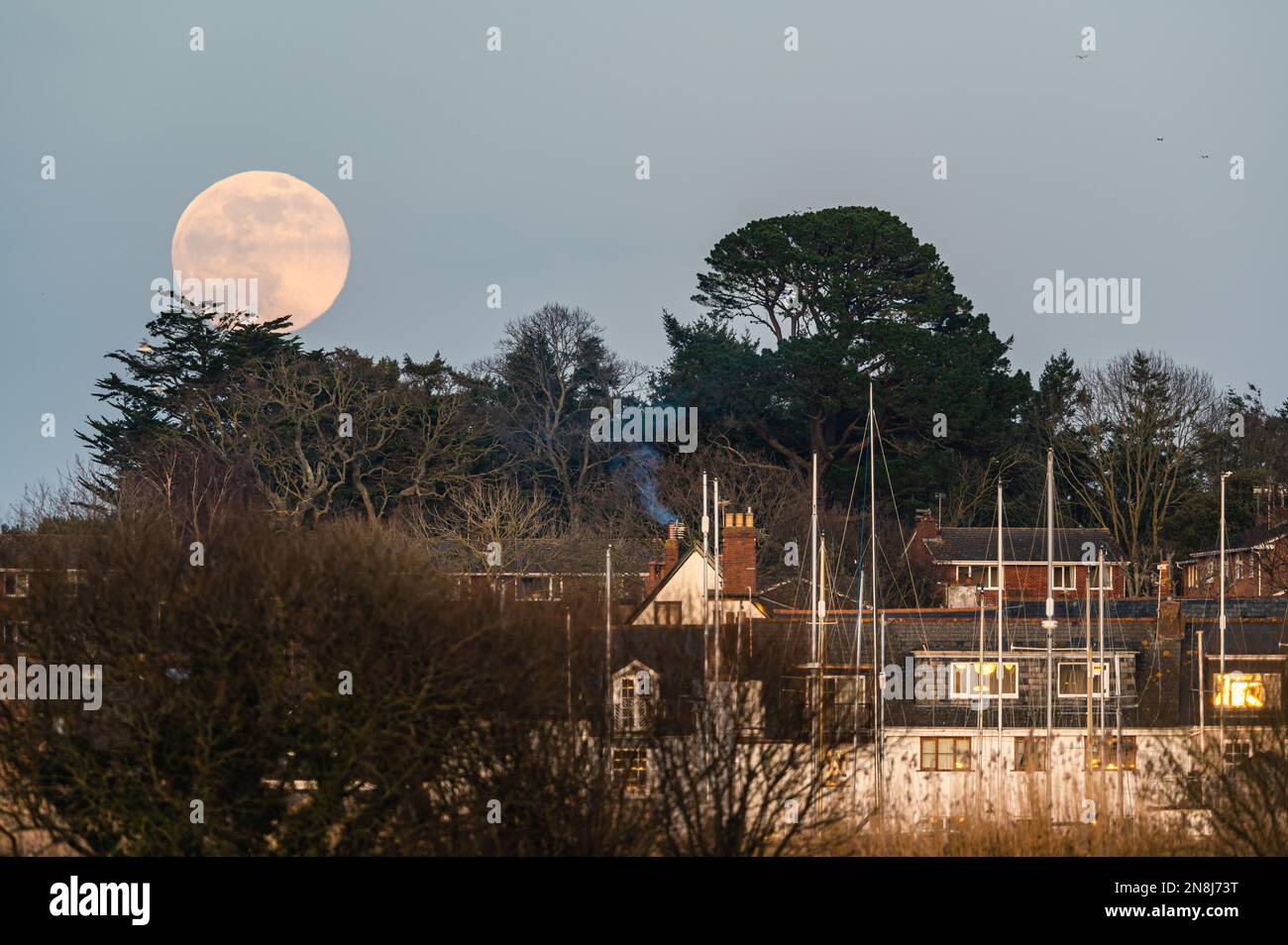 The rising moon at sunset over marshes, Topsham, Devon, England, Europe ...