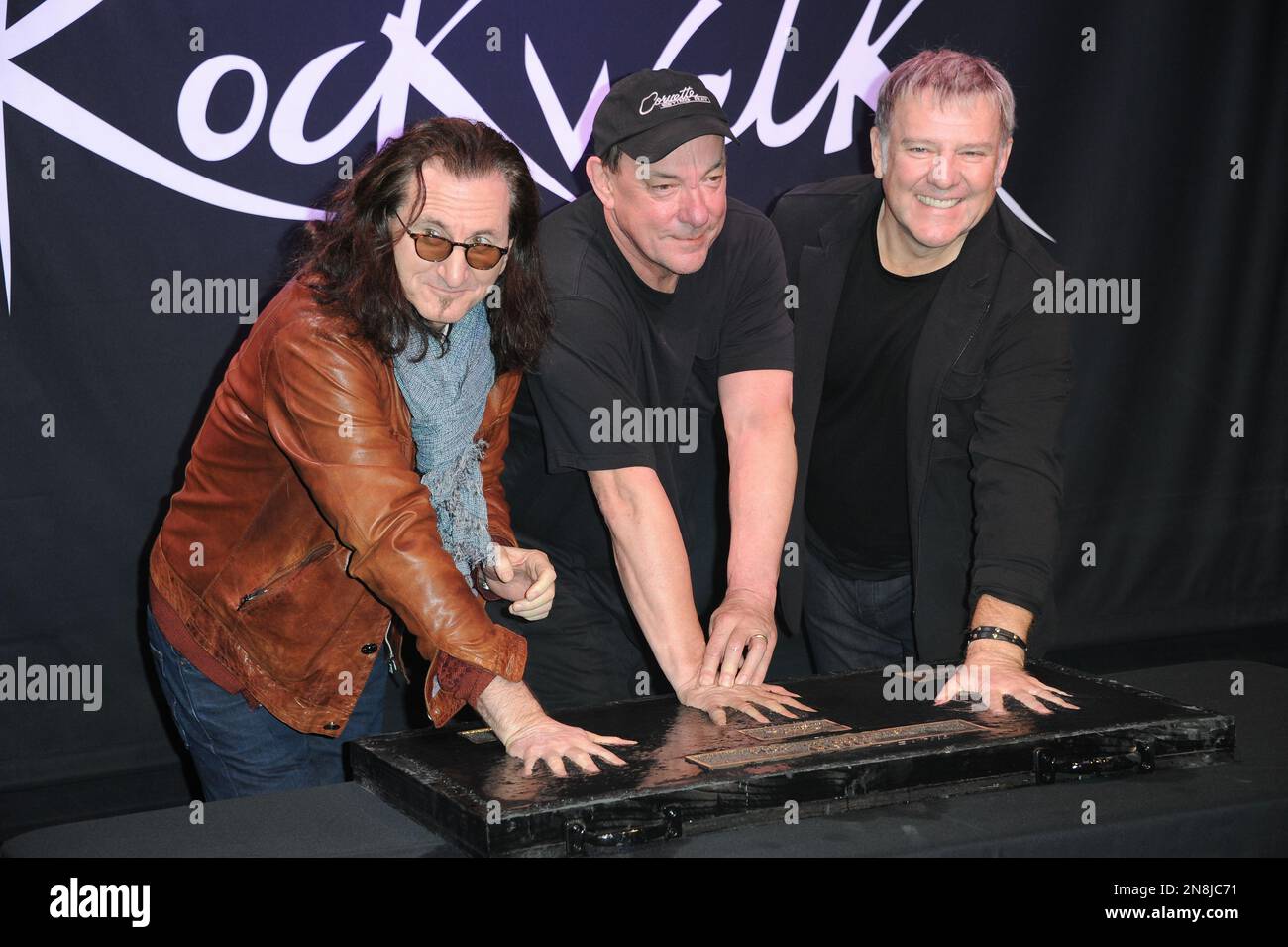 From left, Geddy Lee, Neil Peart, and Alex Lifeson attend the RockWalk induction of Rush at ...