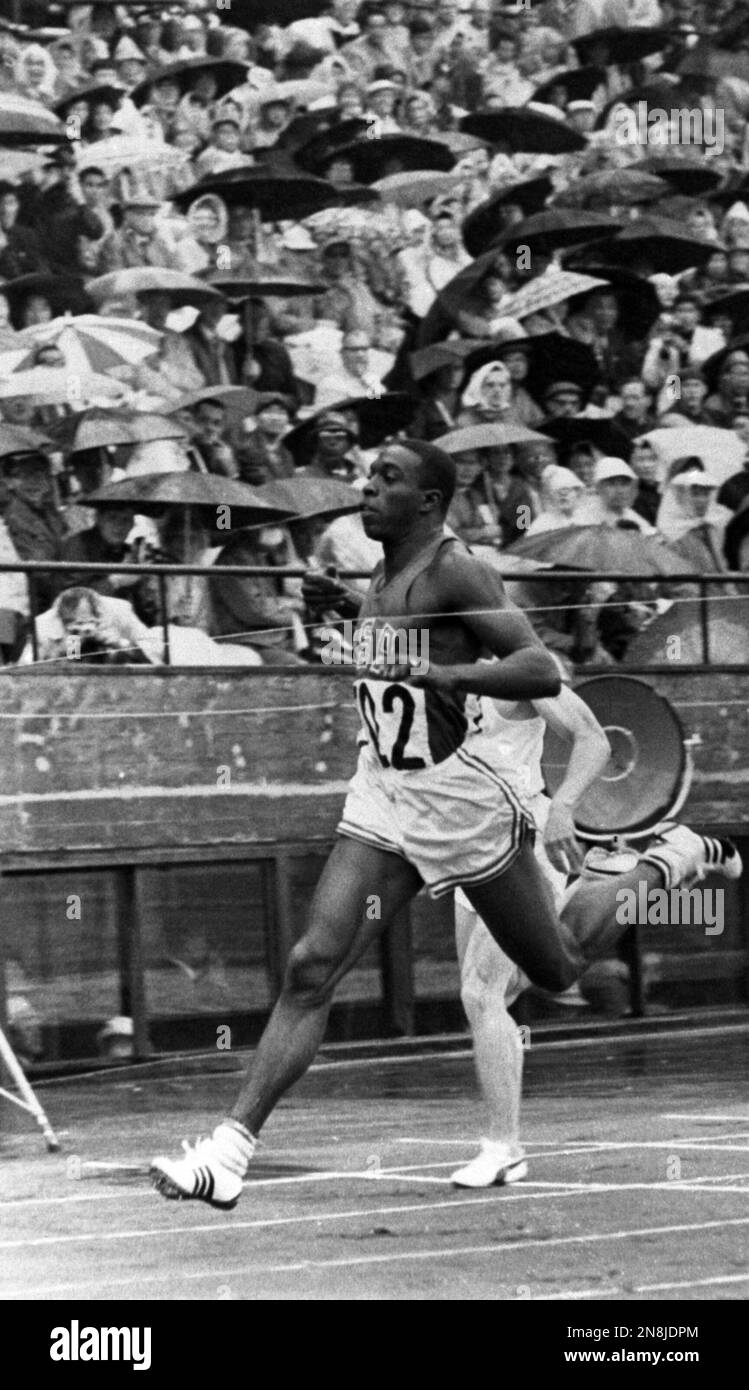 Bob Hayes of Jacksonville, Fla., hits the finish line in the 100-meter event in Tokyo during the ...