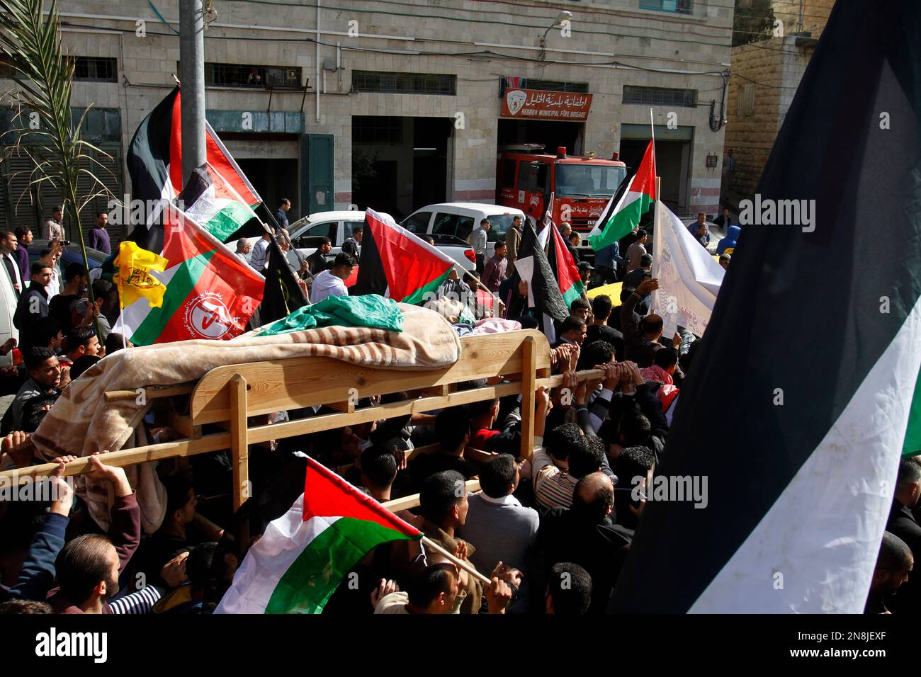 Palestinian mourners carry the body of Hamdi al-Falah, who died during ...
