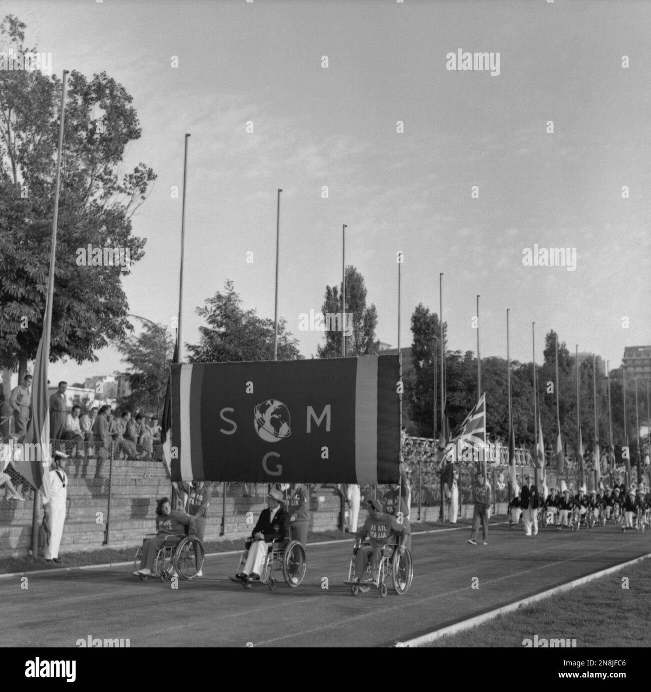 Disabled athletes in wheelchairs carry the official banner of the ...