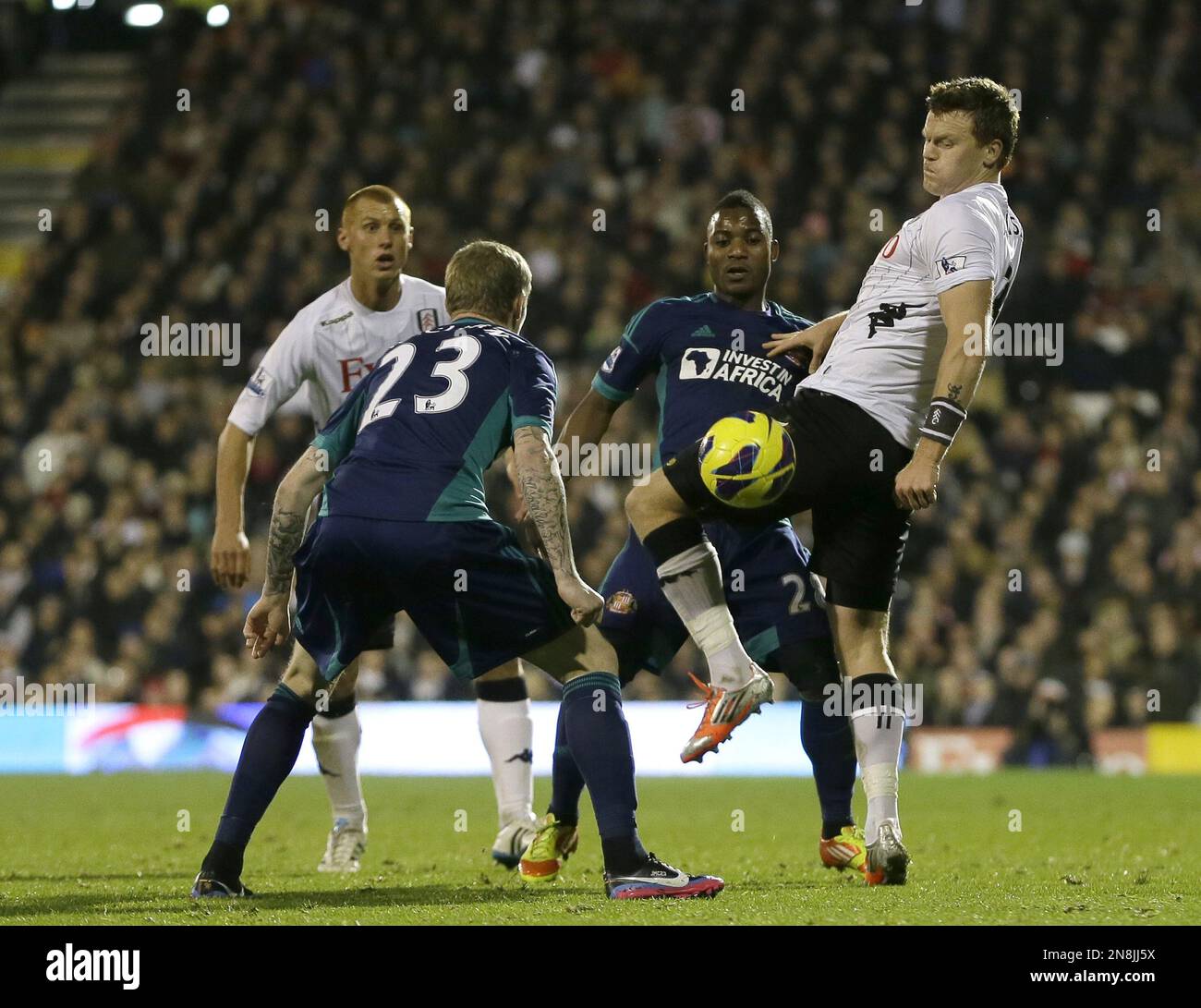 Fulham's John Arne Riise, right, touches the ball past Sunderland's ...
