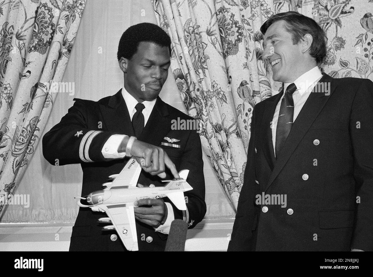 Navy Lt. Robert Goodman Jr. smiles while holding a model of an A-6E ...
