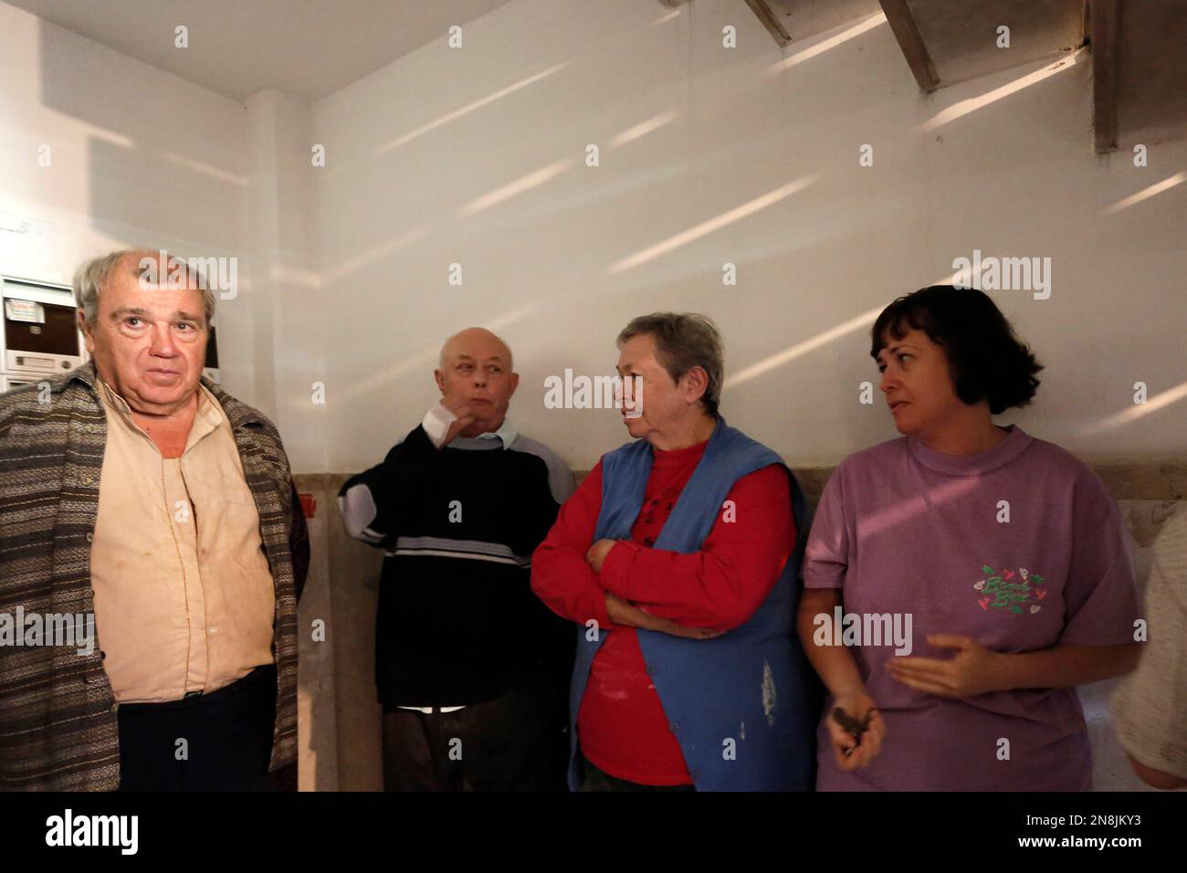 Israelis take cover in a stairwell as a siren signals the warning of ...