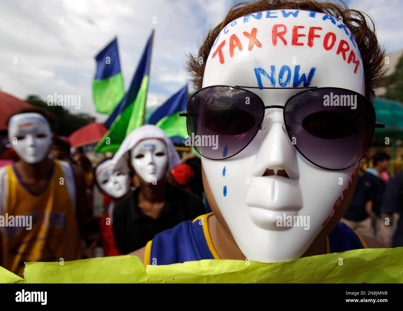 A Filipino protester wears a mask bearing a slogan as tobacco farmers ...