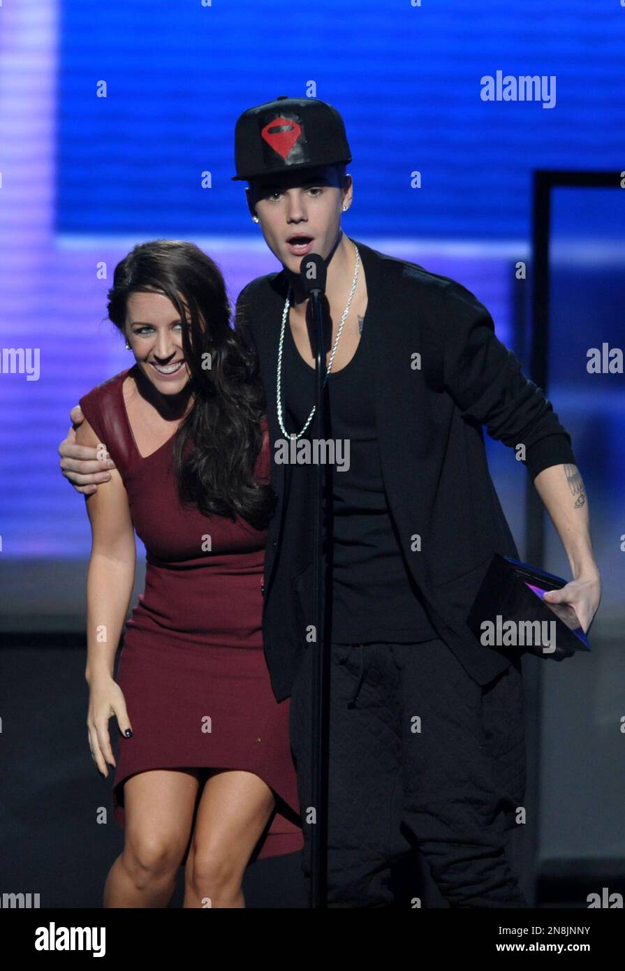 Justin Bieber accepts the award for artist of the year as he embraces ...