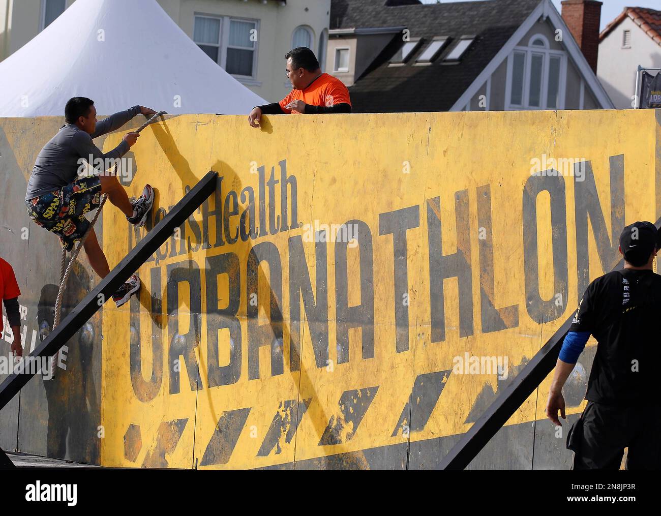 Urbanathlete scales an eight-foot wall obstacle during the Men's Health ...