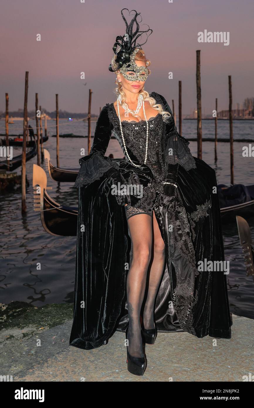 Venice, Italy. 11th Feb, 2023. A young woman in risque costume poses by ...