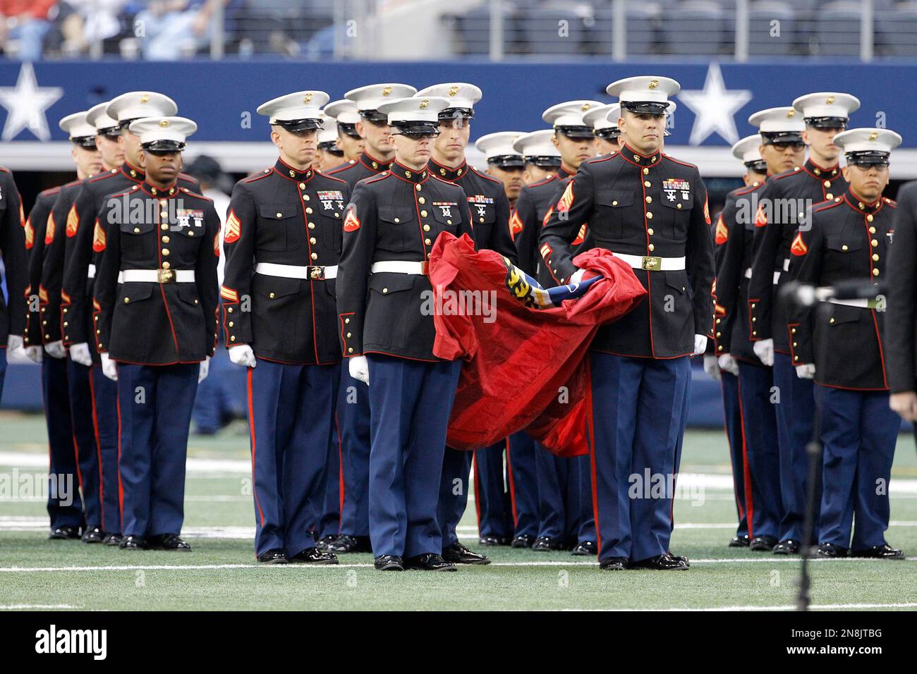 US Marines stand on the field at halftime of an NFL football game ...
