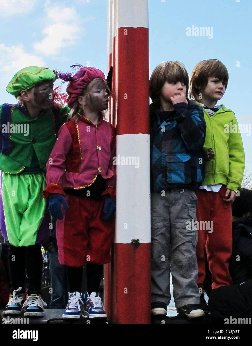 Children dressed as "Zwarte Piet" or "Black Pete", left, await the ...