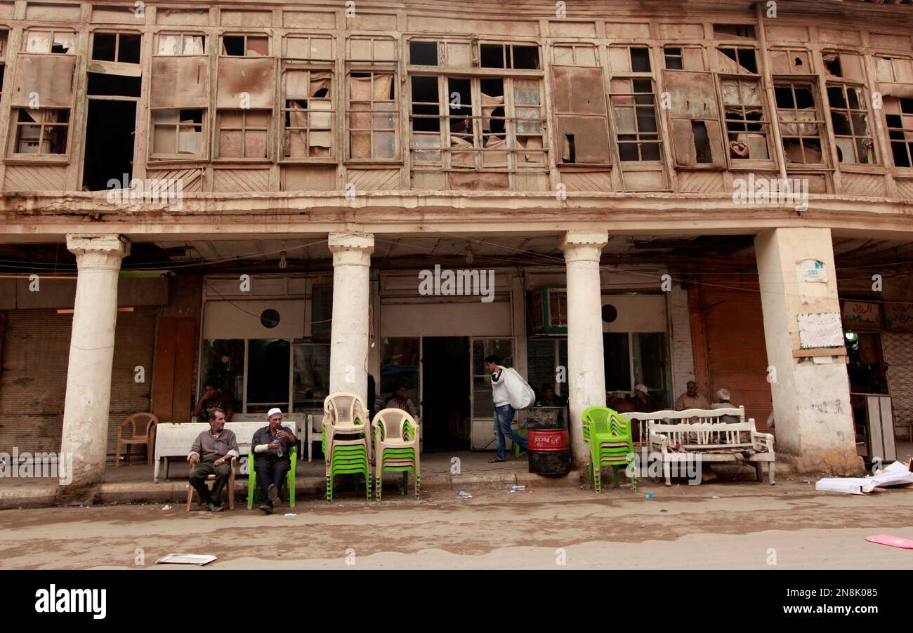 Patrons sit outside a cafe at al-Rasheed street, the oldest street in ...