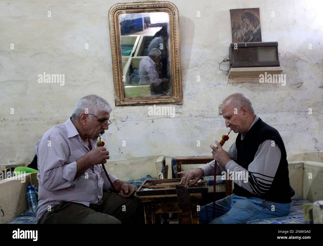 Patrons sit in a cafe at al-Rasheed street, the oldest street in ...