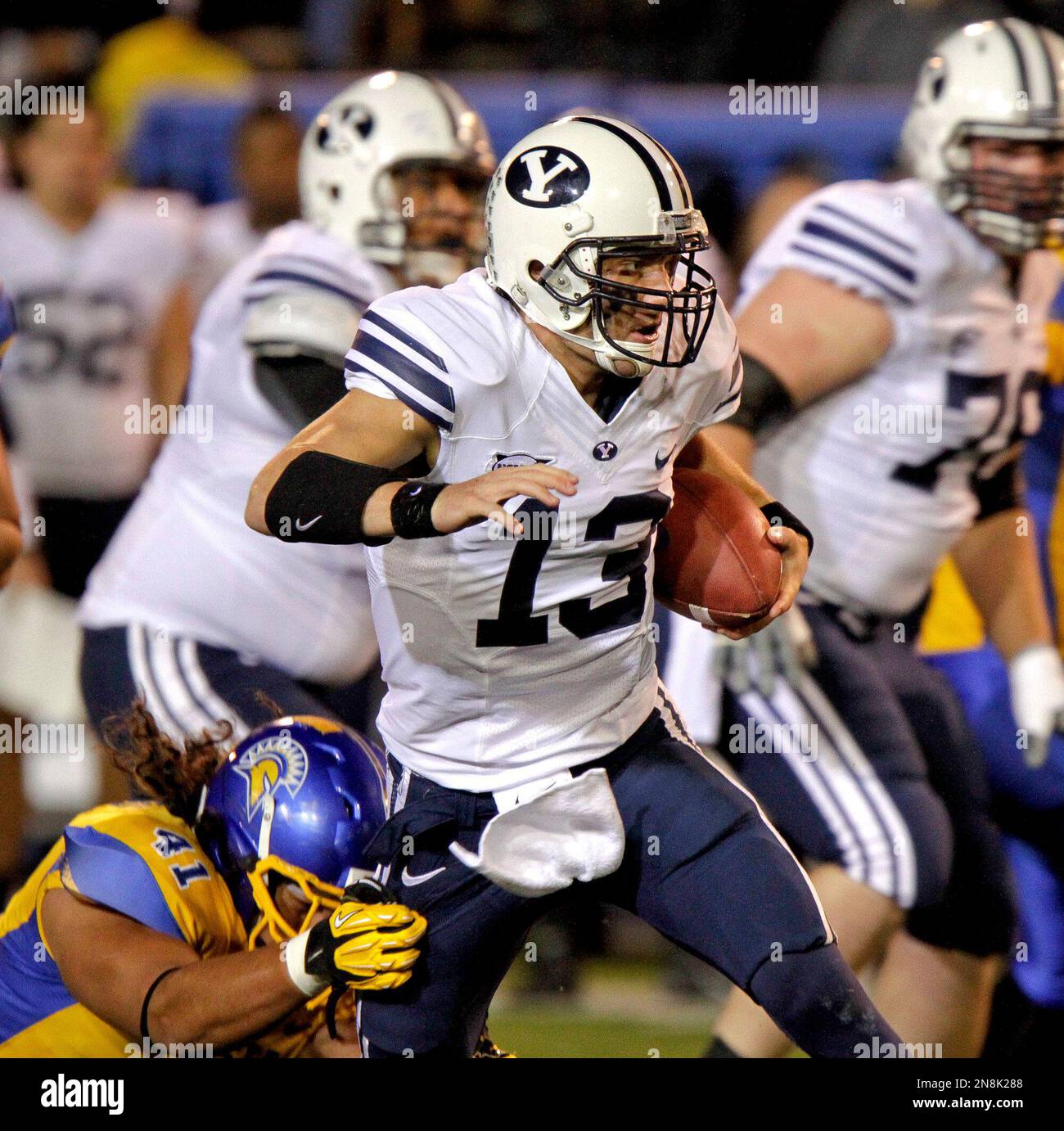 Brigham Young quarterback Riley Nelson (13) breaks a tackle by San Jose ...