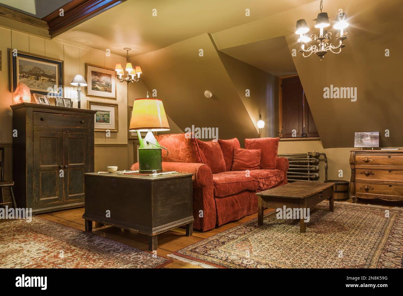 Upstairs family room with crimson red upholstered sofa, wooden armoire ...
