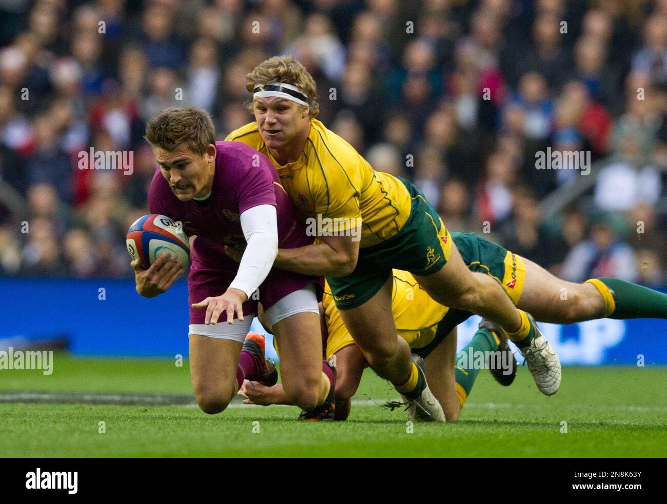 England's Toby Flood, left, is tackled by Australia's Michael Hooper ...