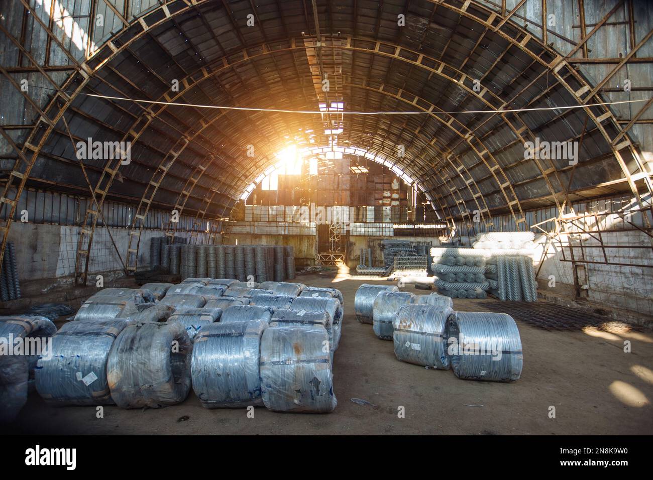 Rolls of galvanized steel wire, fittings and wire mesh in warehouse ...