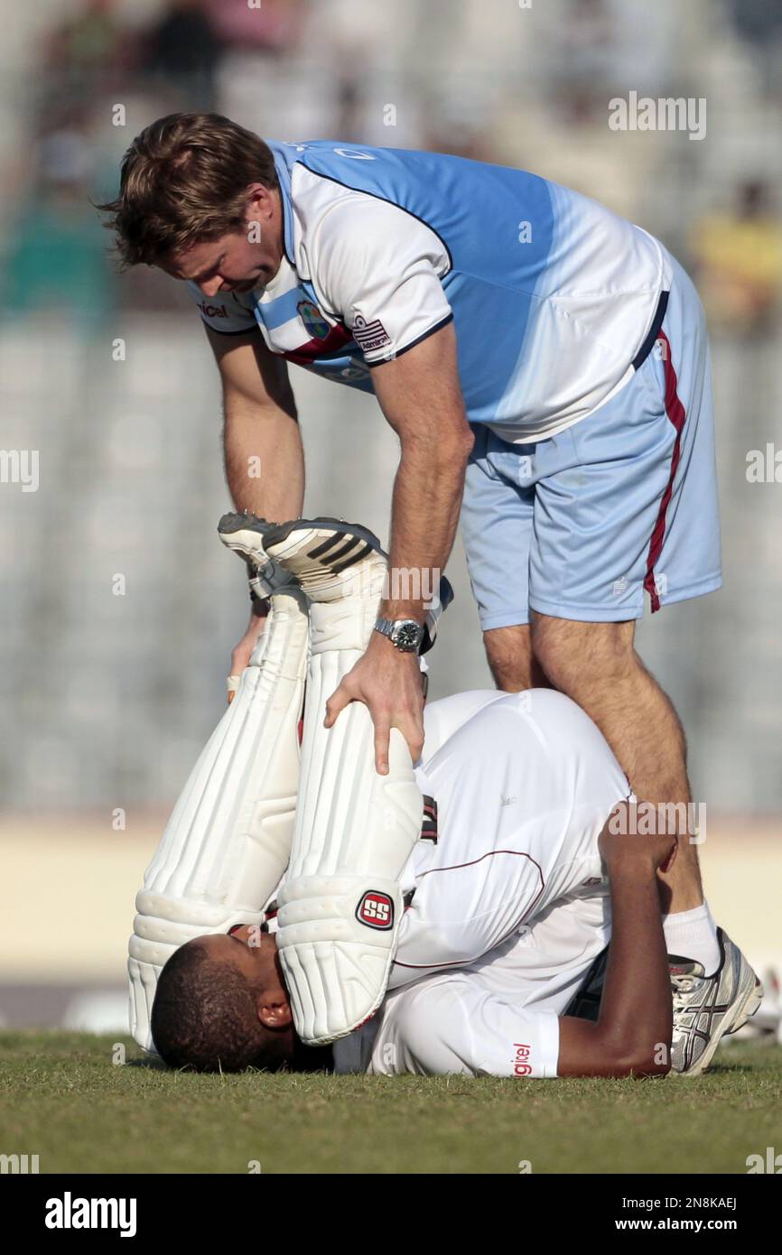 West Indies' Kieran Powell stretches with the help of an unidentified ...