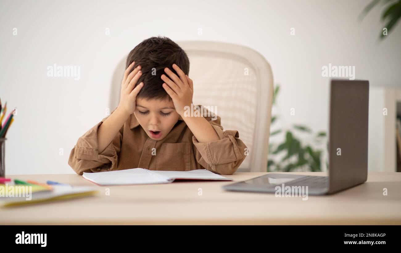 Shocked sad european small kid with open mouth hold head with hands ...