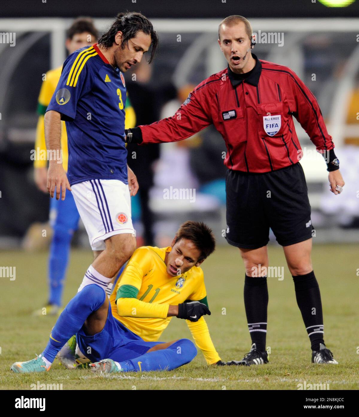 Colombia's Mario Alberto Yepes, left, stands over Brazil's Neymar as referee Mark Geiger, right ...