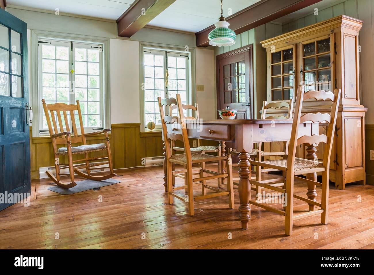 Dining room with pine wood table and woven seat chairs, rocking chair ...