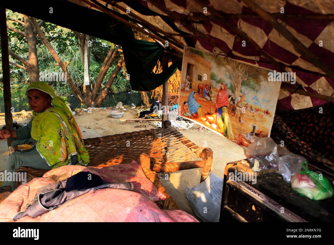 A Pakistani woman sits in her make-shift tent in the slums of Lahore ...