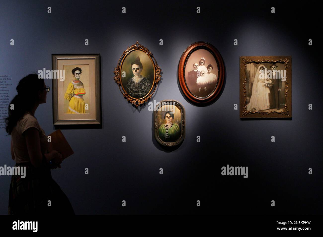 A visitor looks at family portraits by Mexican artist Marcos Raya on ...