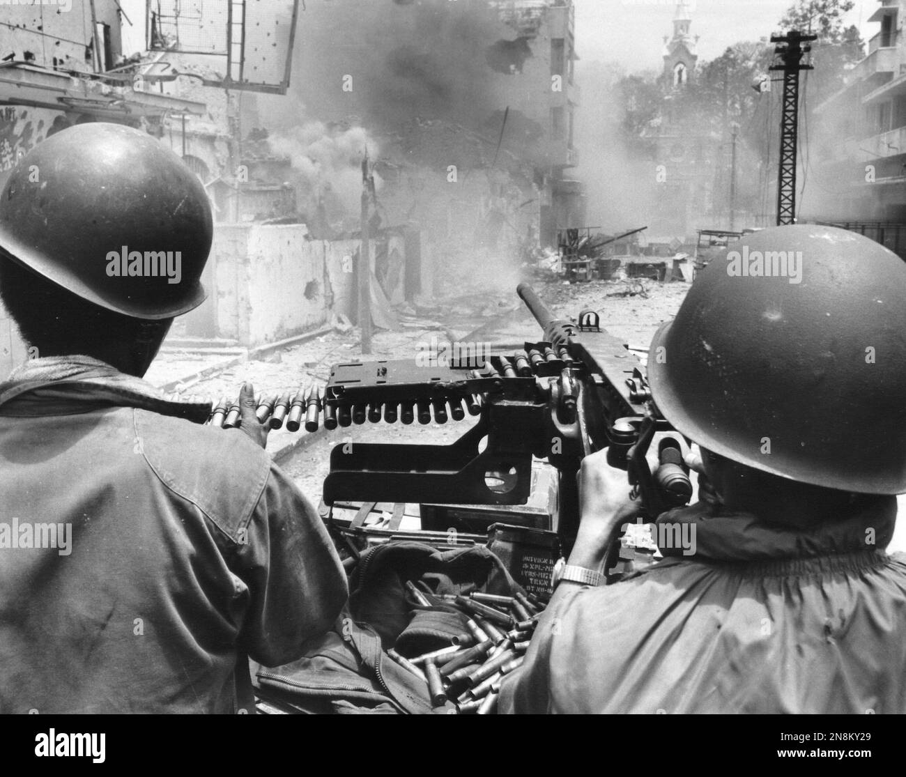 A Vietnamese army tank slowly advances through the rubble-strewn ...