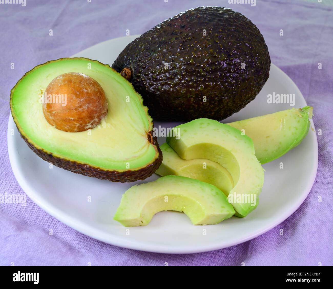Two fresh ripe raw hass avocados, close up, healthy food concept close ...