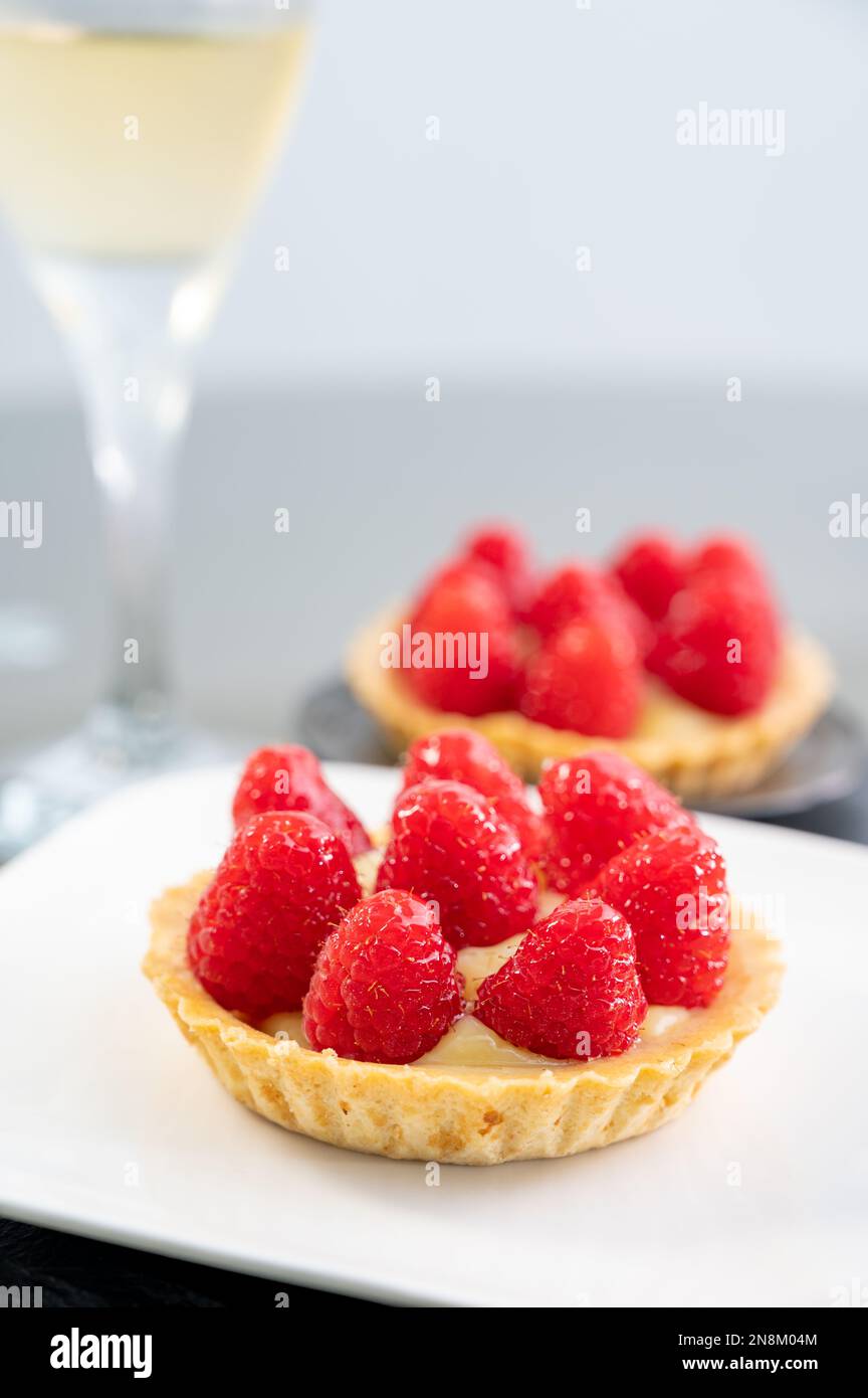 Artisanal baked small tart with cream and fresh ripe red raspberry ...