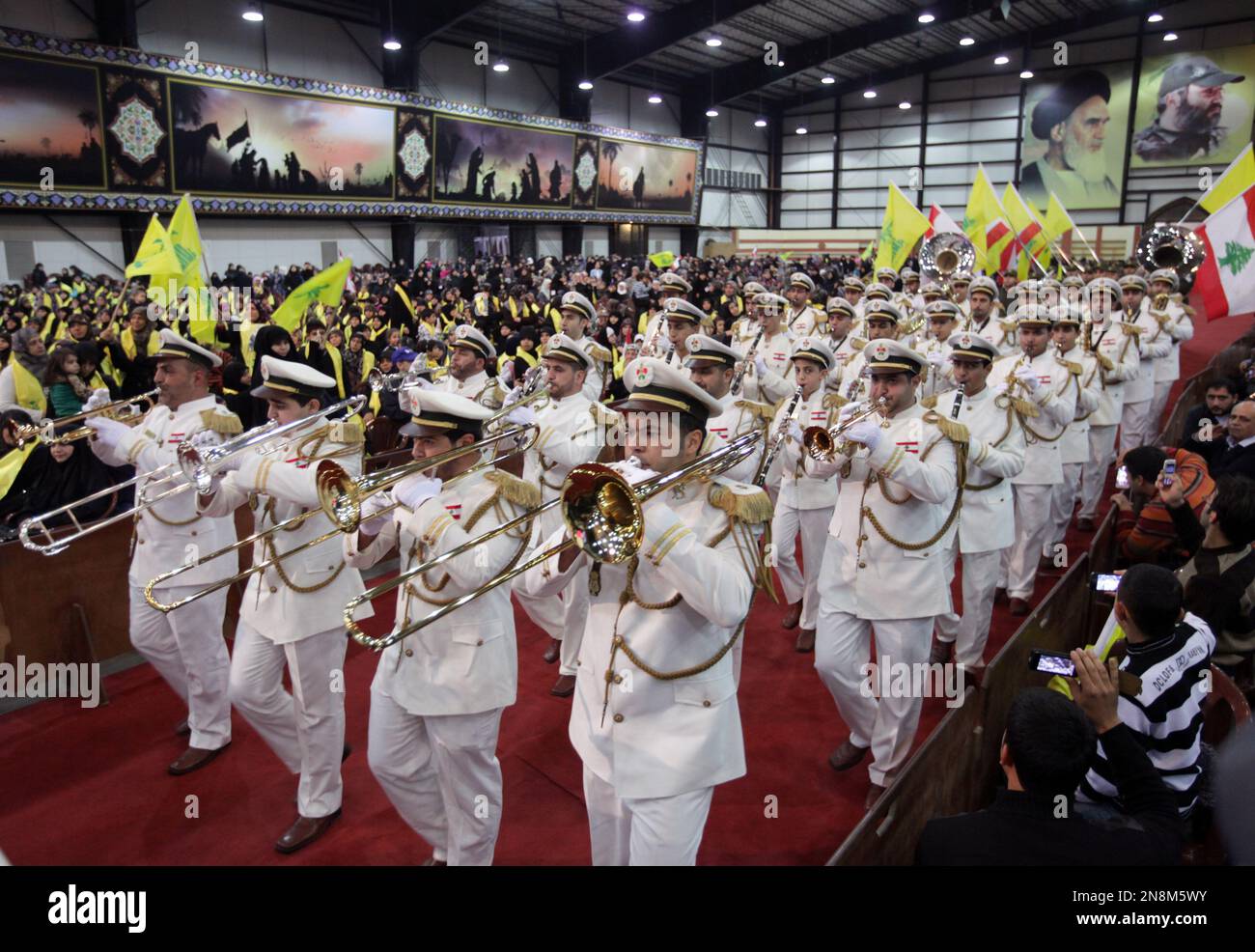 Hezbollah members, hold Hezbollah and Lebanese flags as they march ...