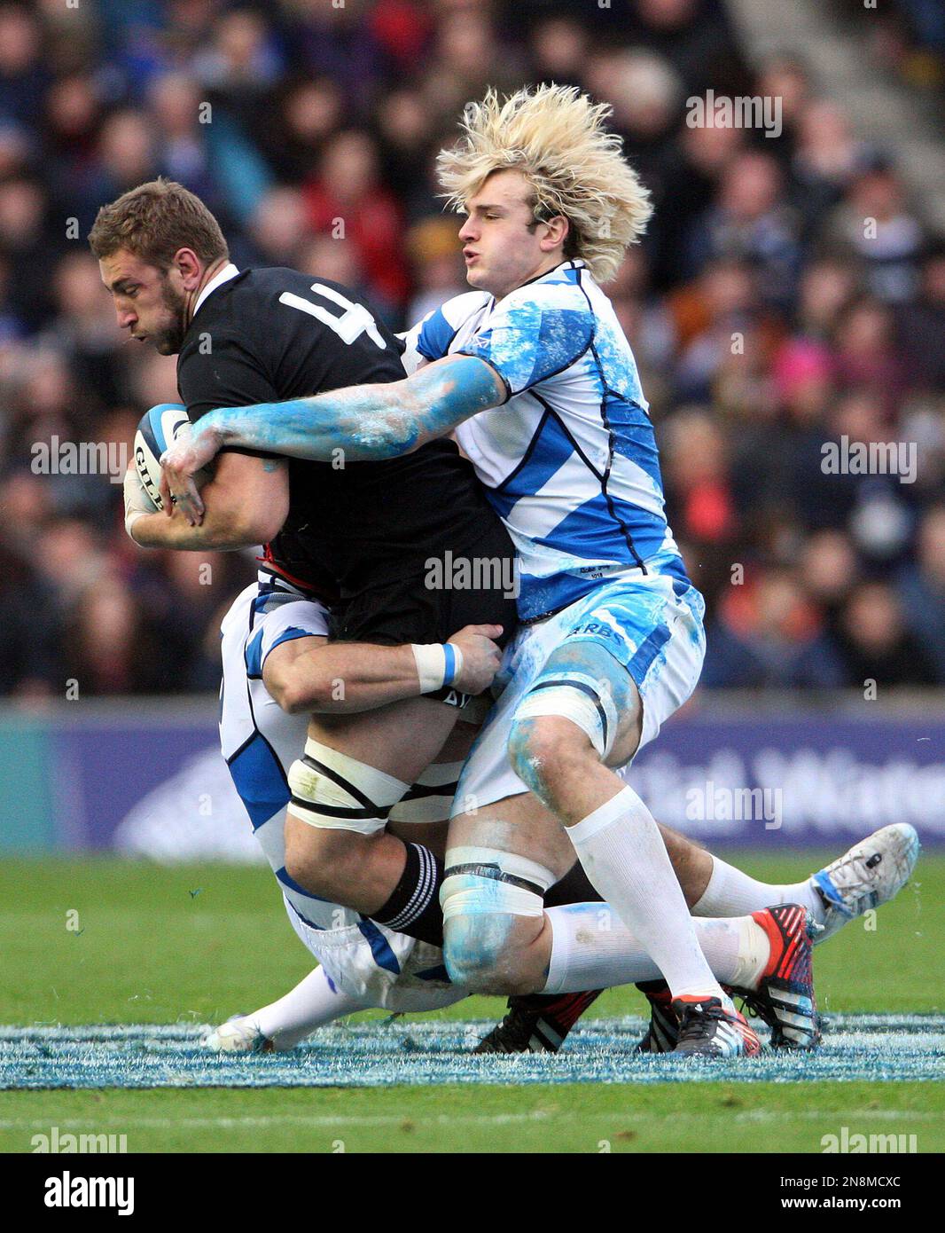 New Zealand's Luke Romano, centre, is tackled by Scotland's Alasdair ...