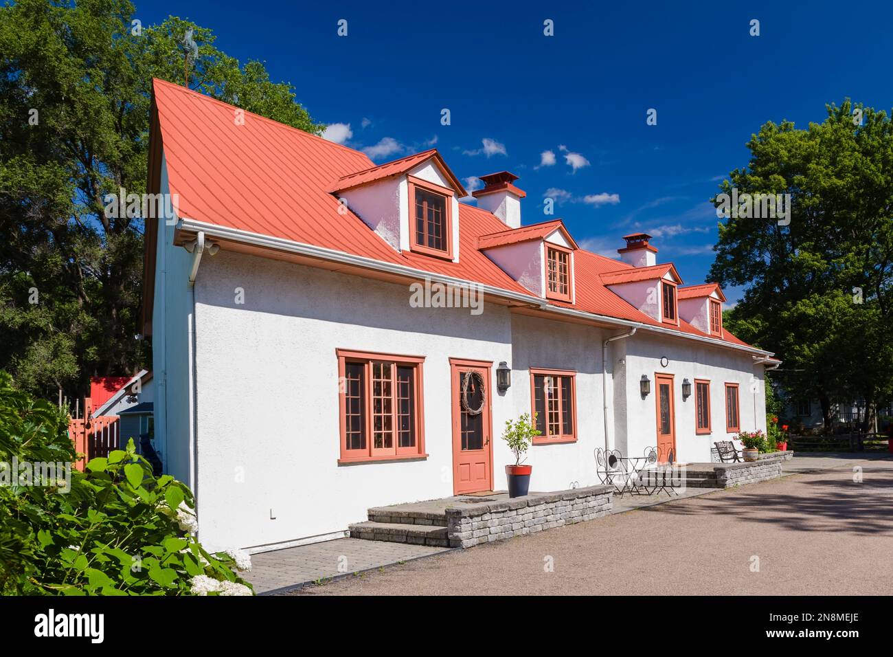 Old 1850 white stucco and peach Canadiana cottage style house facade ...