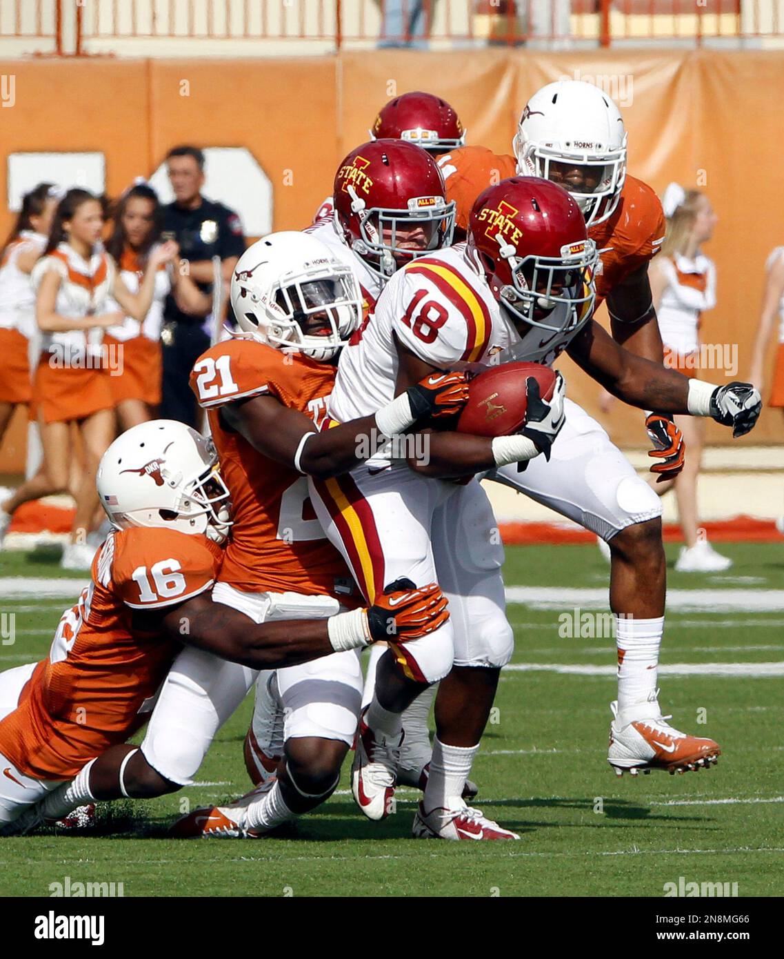 Iowa State receiver Albert Gary (18) drags Texas defenders Duke Thomas ...